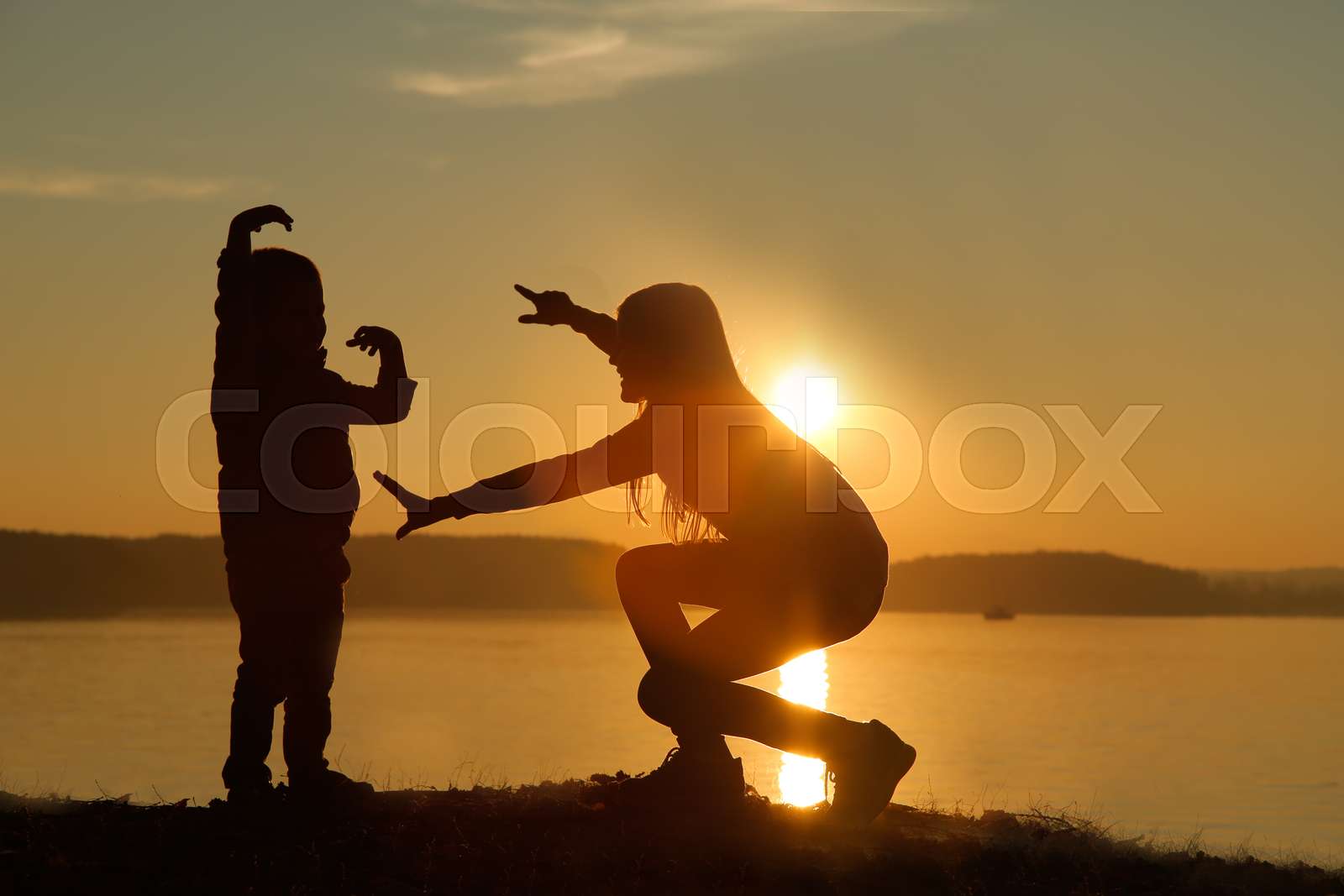 Children by the sea at sunset playing scaring each other | Stock image ...