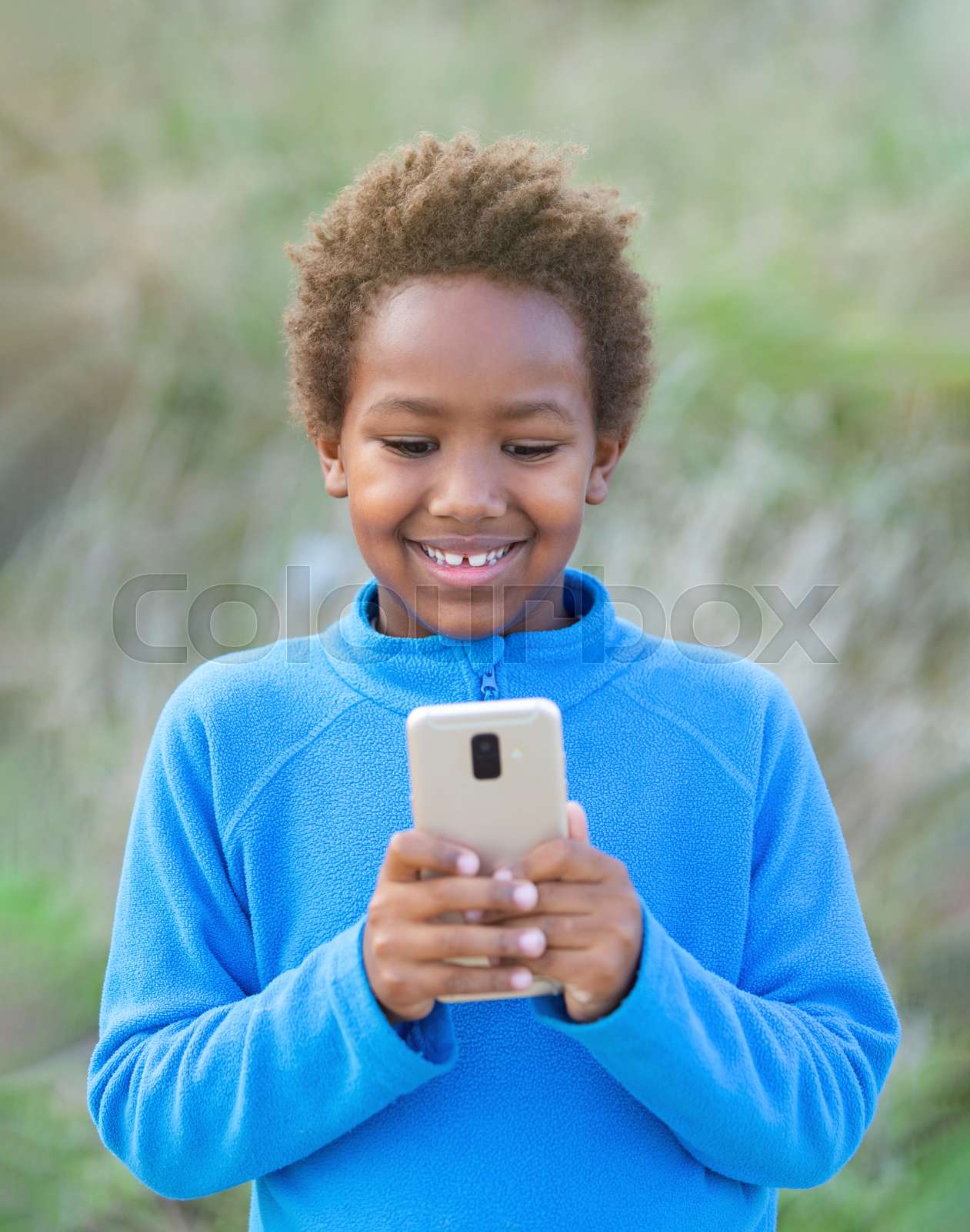 Adorable african child with a mobile phone | Stock image | Colourbox