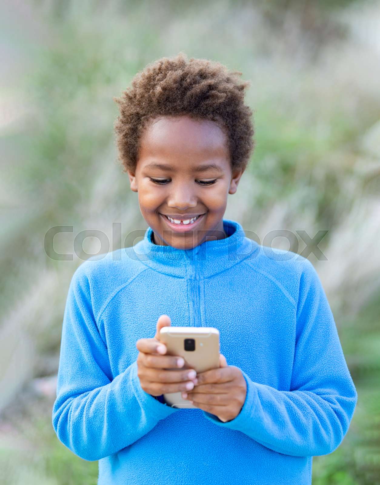 Adorable african child with a mobile phone | Stock image | Colourbox
