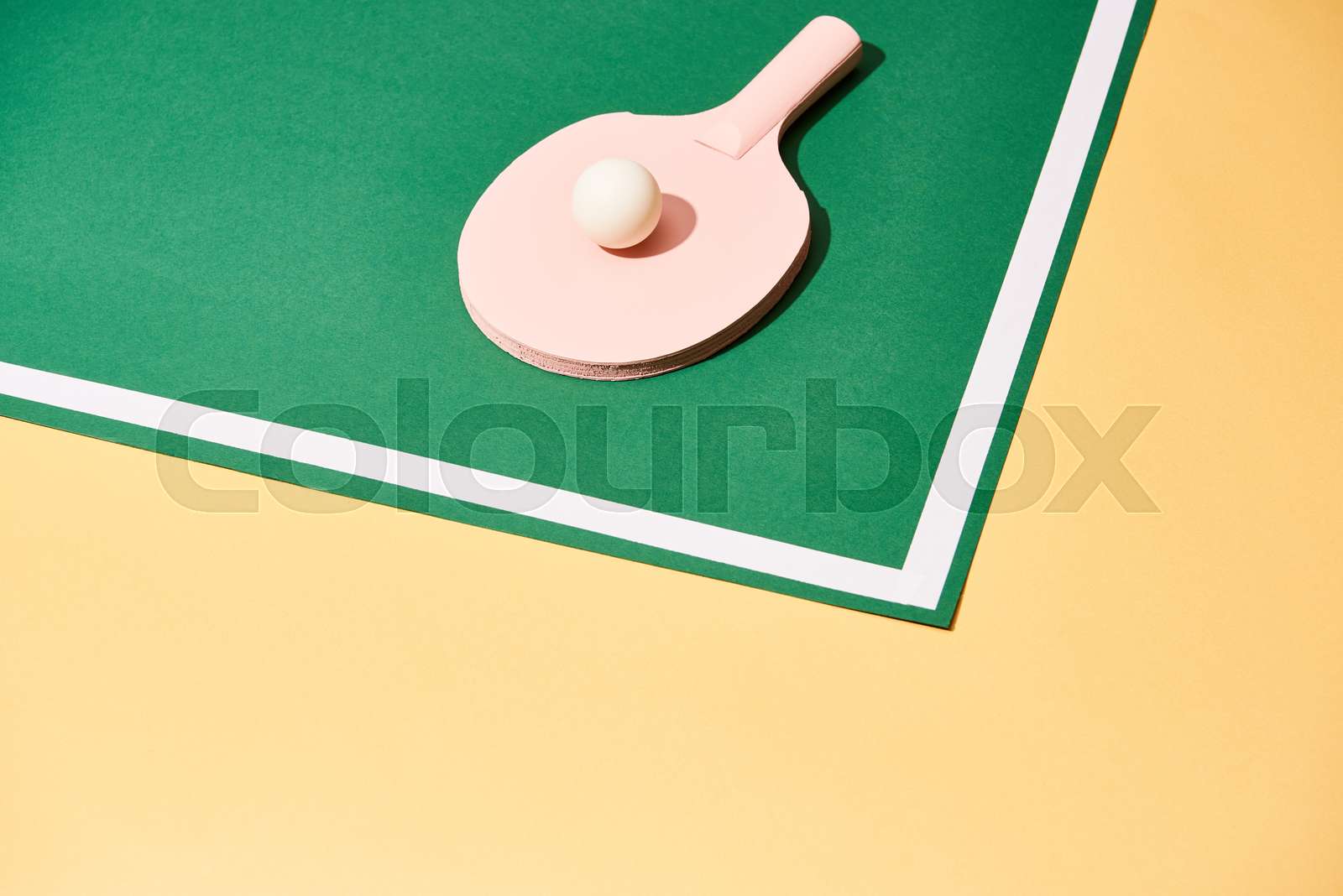 Ping pong ball on racket and playing table on yellow surface | Stock ...