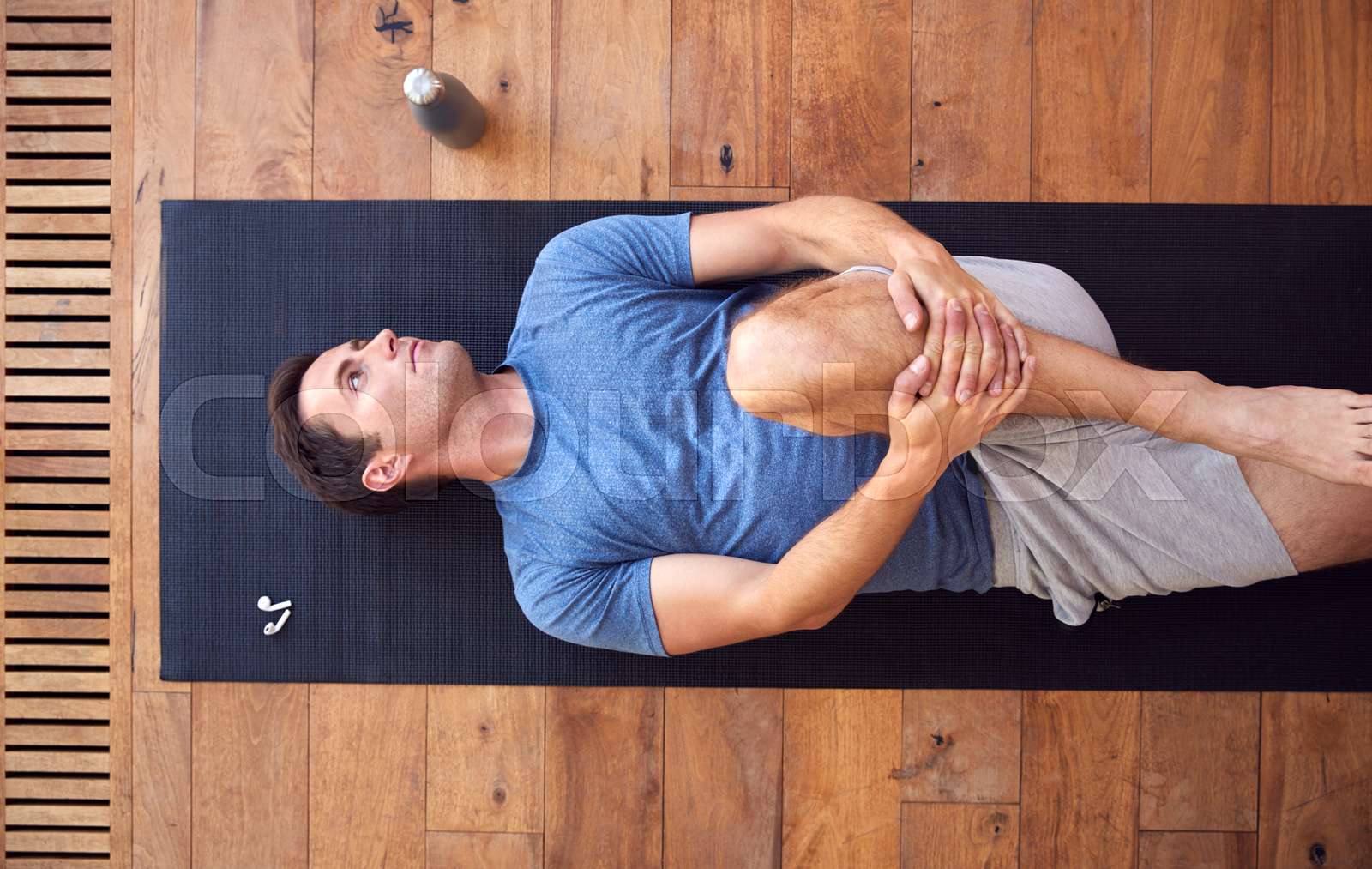 Overhead View Of Man Lying On Exercise Mat On Wooden Floor | Stock ...