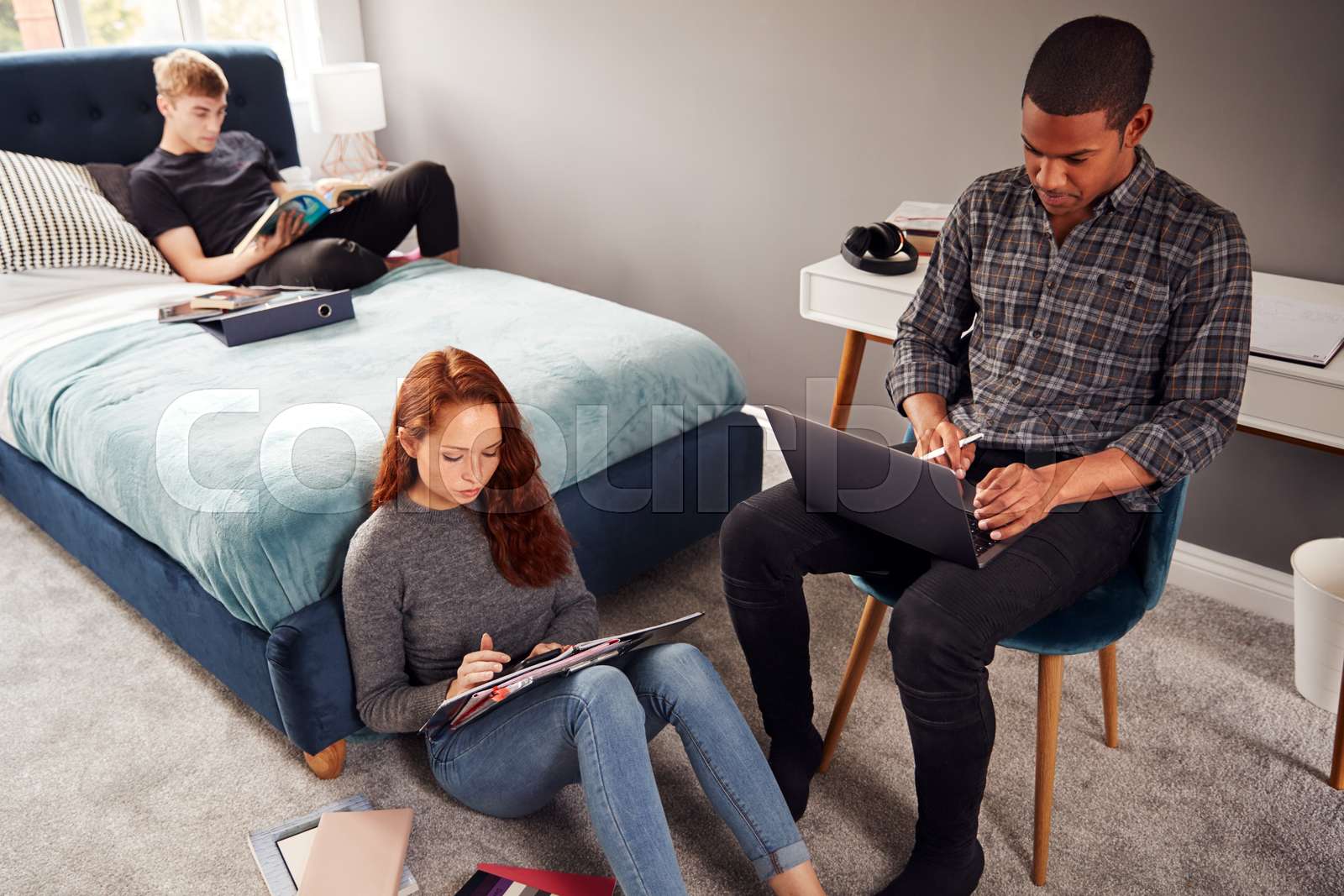 Group Of College Students In Shared House Bedroom Studying Together ...