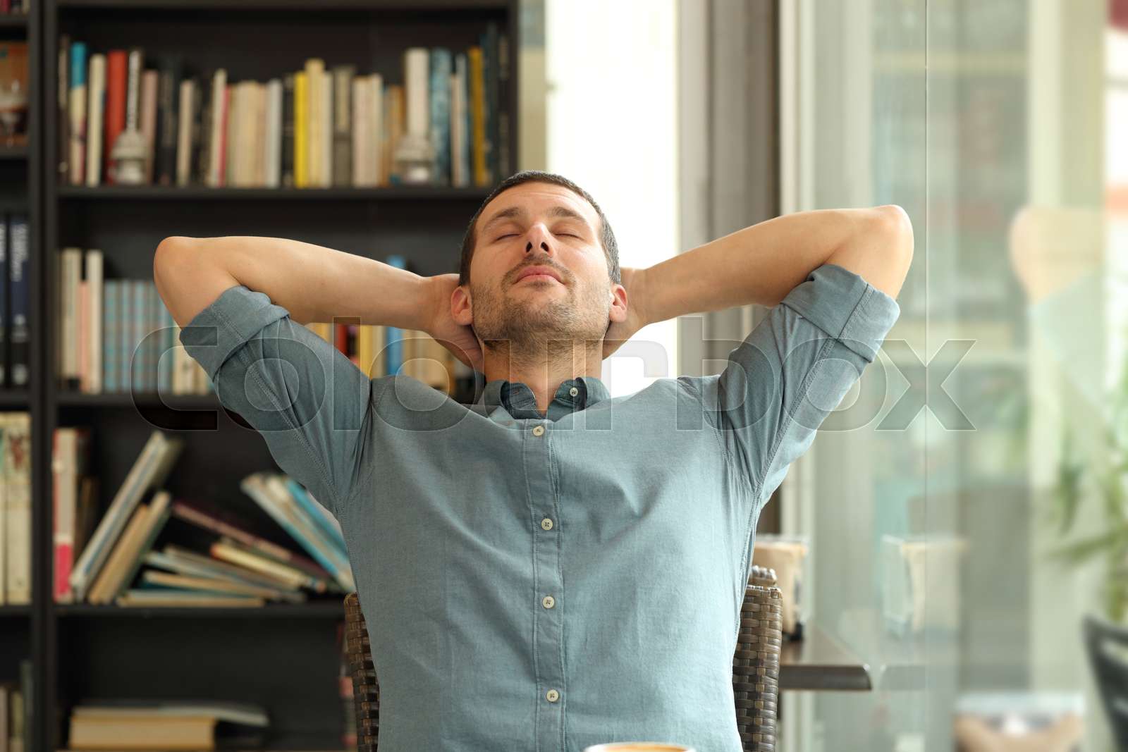 Front view of a relaxed man resting sitting with arms on head | Stock ...