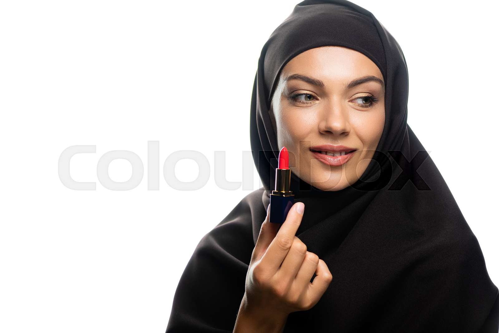smiling young Muslim woman in hijab holding red lipstick isolated on ...