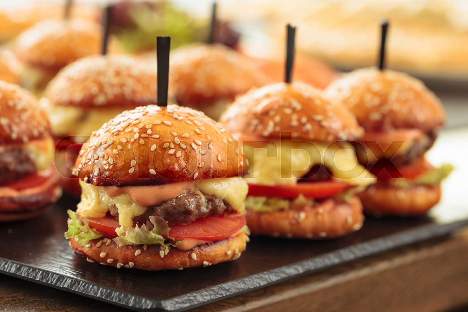 Burgers on wooden table in restaurant . | Stock image | Colourbox