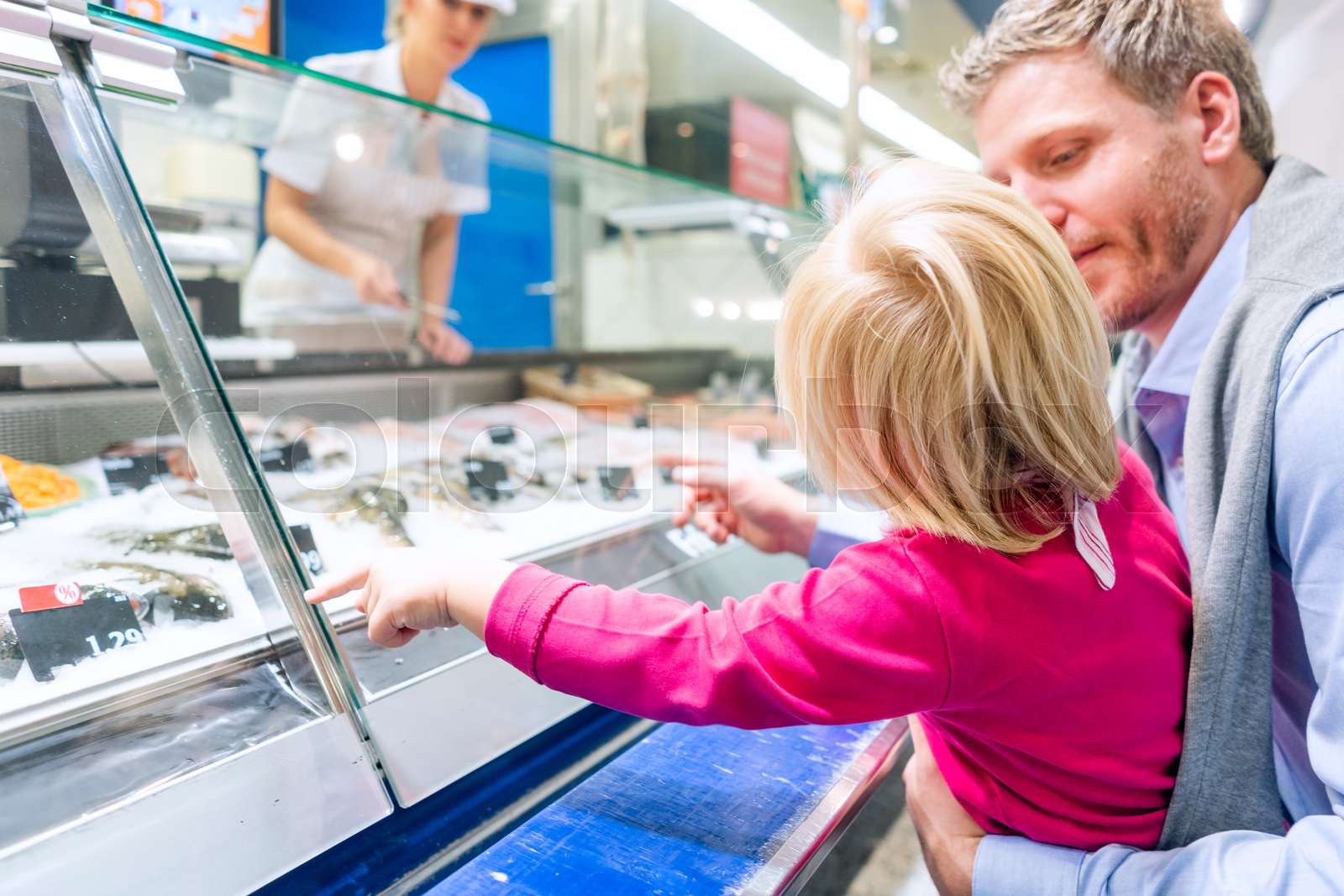 Family at the fish counter in a supermarket | Stock image | Colourbox