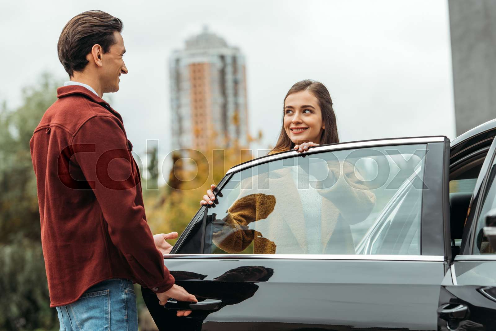 Smiling taxi driver opening car door for woman | Stock image | Colourbox