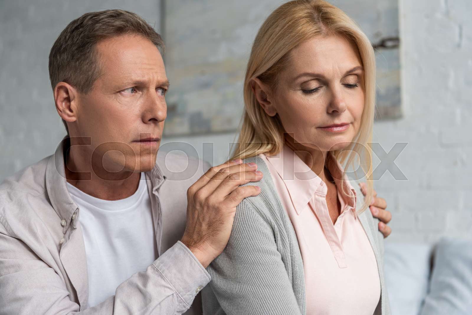 Man calming down worried wife at home | Stock image | Colourbox