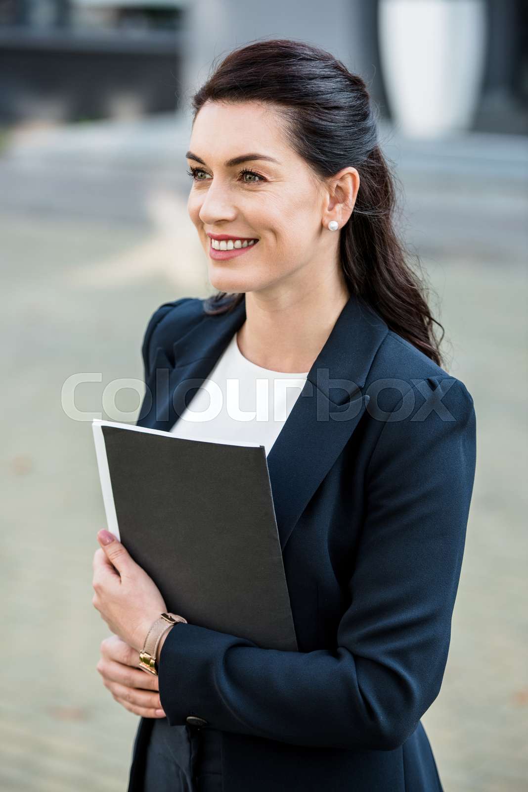 attractive diplomat holding folder and smiling outside | Stock image ...