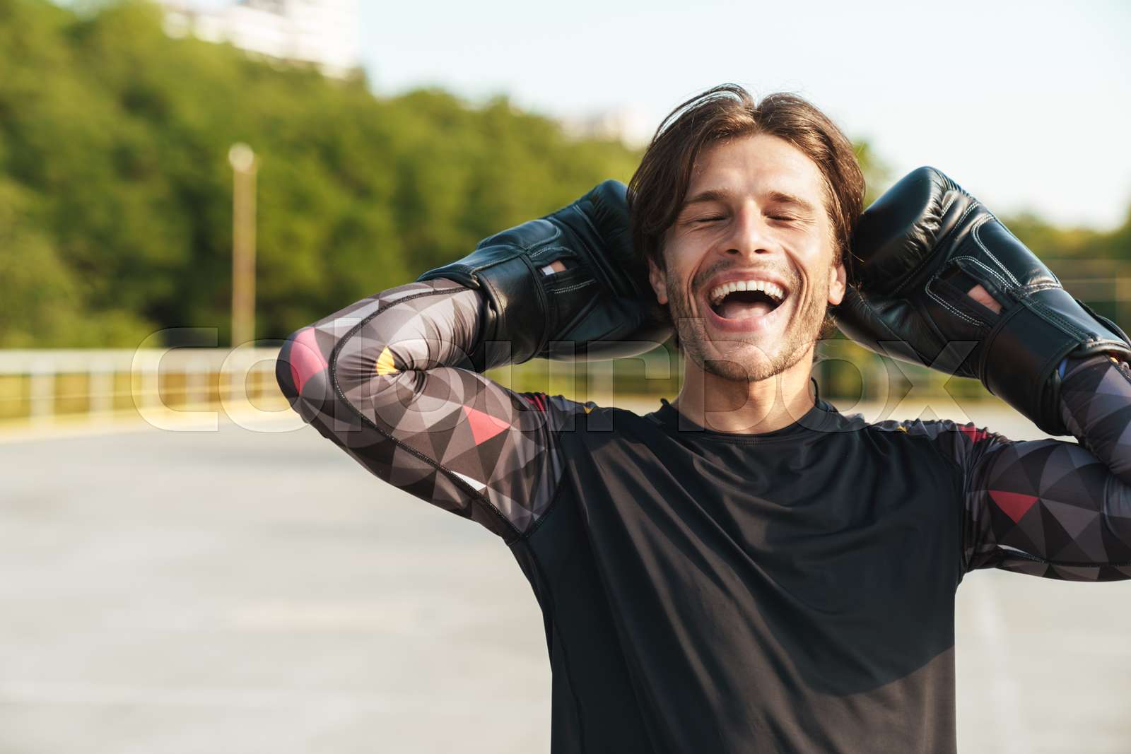 Photo of delighted man grabbing his head in boxing gloves | Stock image ...