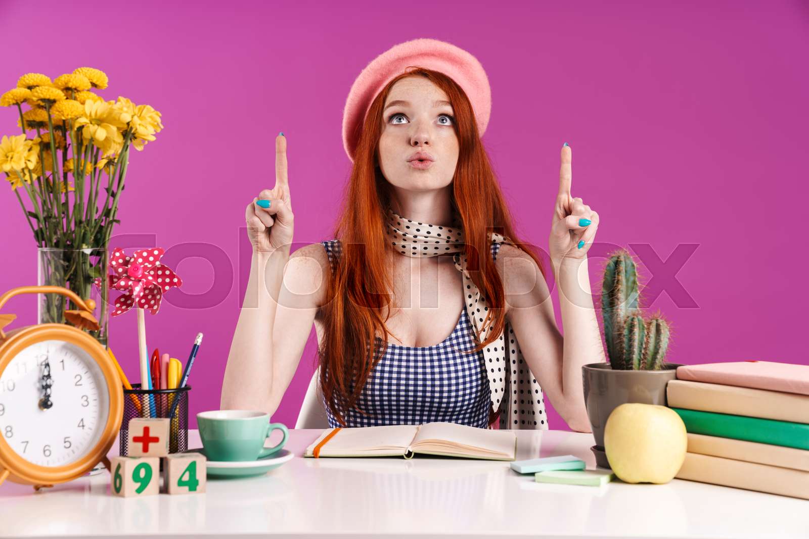 Photo of caucasian student girl pointing fingers upward while doing ...