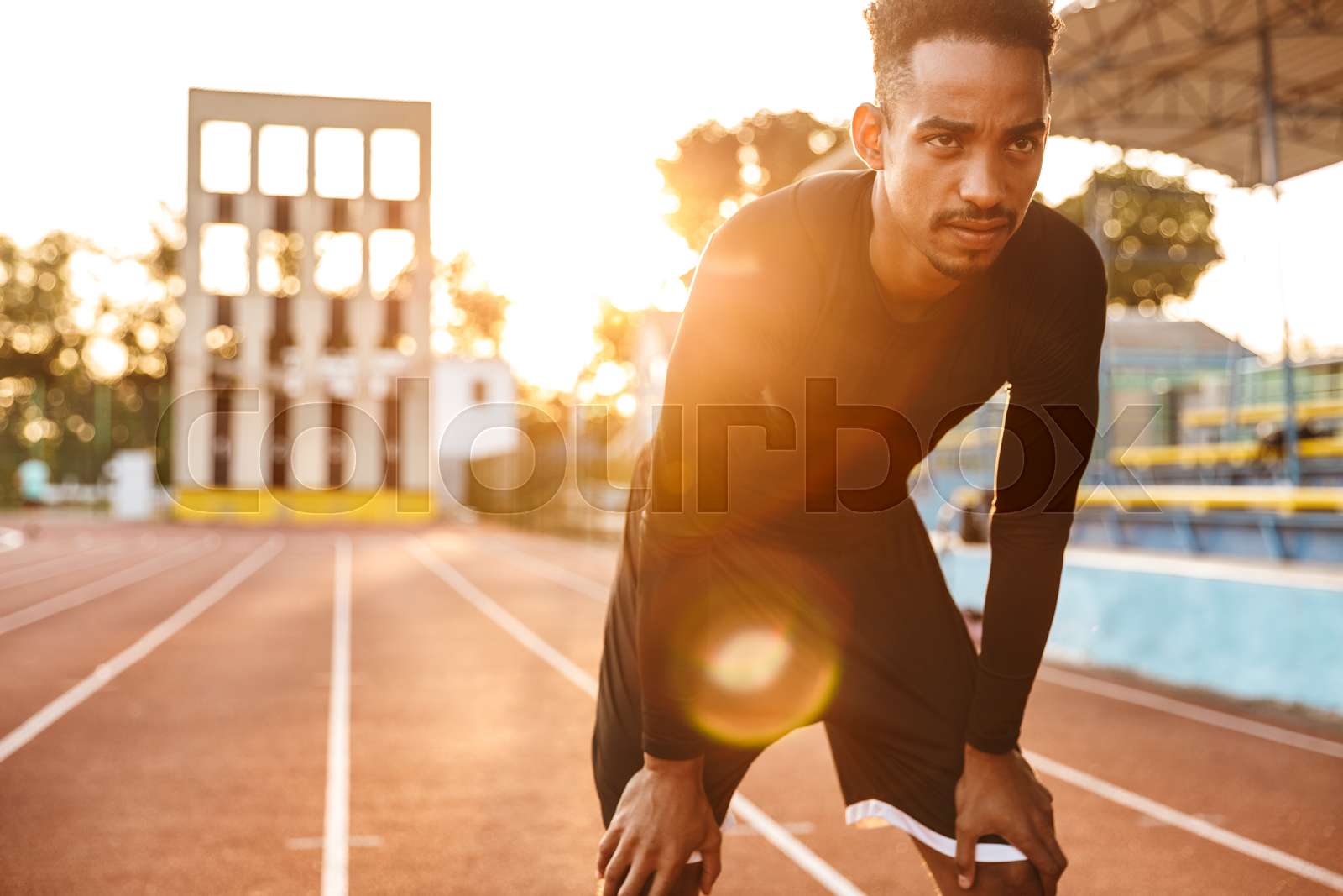 Image of african american man standing at running track on sports ...
