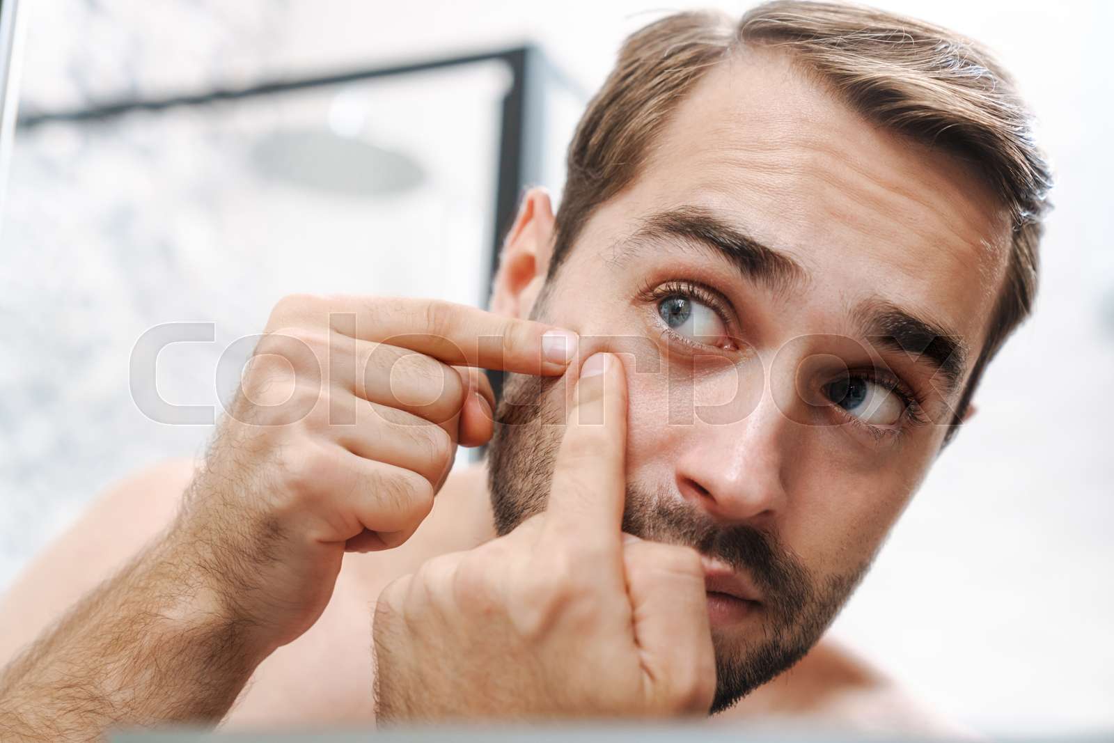 Concerned young man playing with his face | Stock image | Colourbox