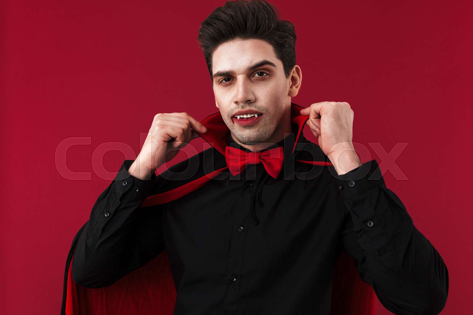 Image of young vampire man with fangs in black halloween costume ...