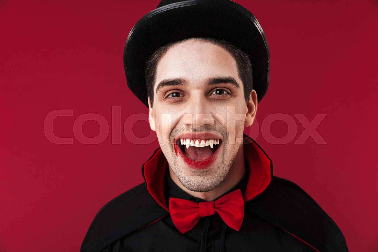 Image of young vampire man with fangs in halloween costume smiling ...