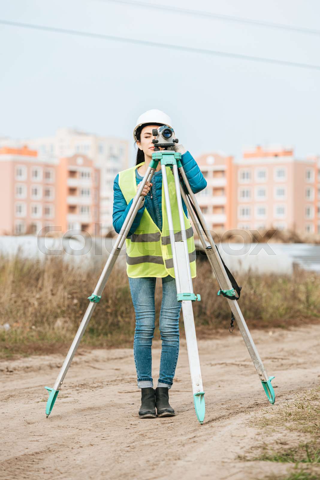 Female Surveyor measuring land with digital level | Stock image | Colourbox