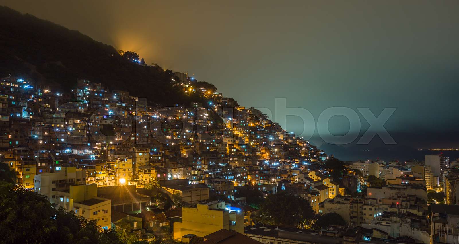 Night over Brazilian favelas on the hill with city downtown below, Rio ...