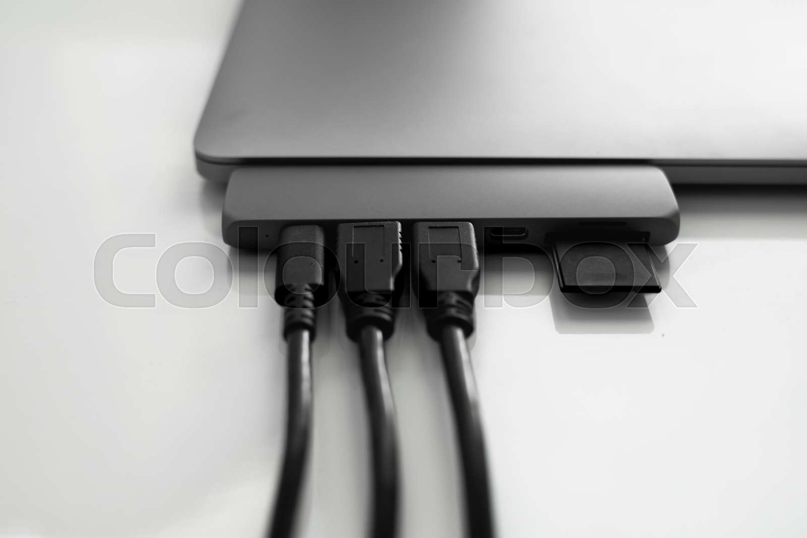 Laptop with USB Type-C adapter with pluged USB cables and SD card. The ...