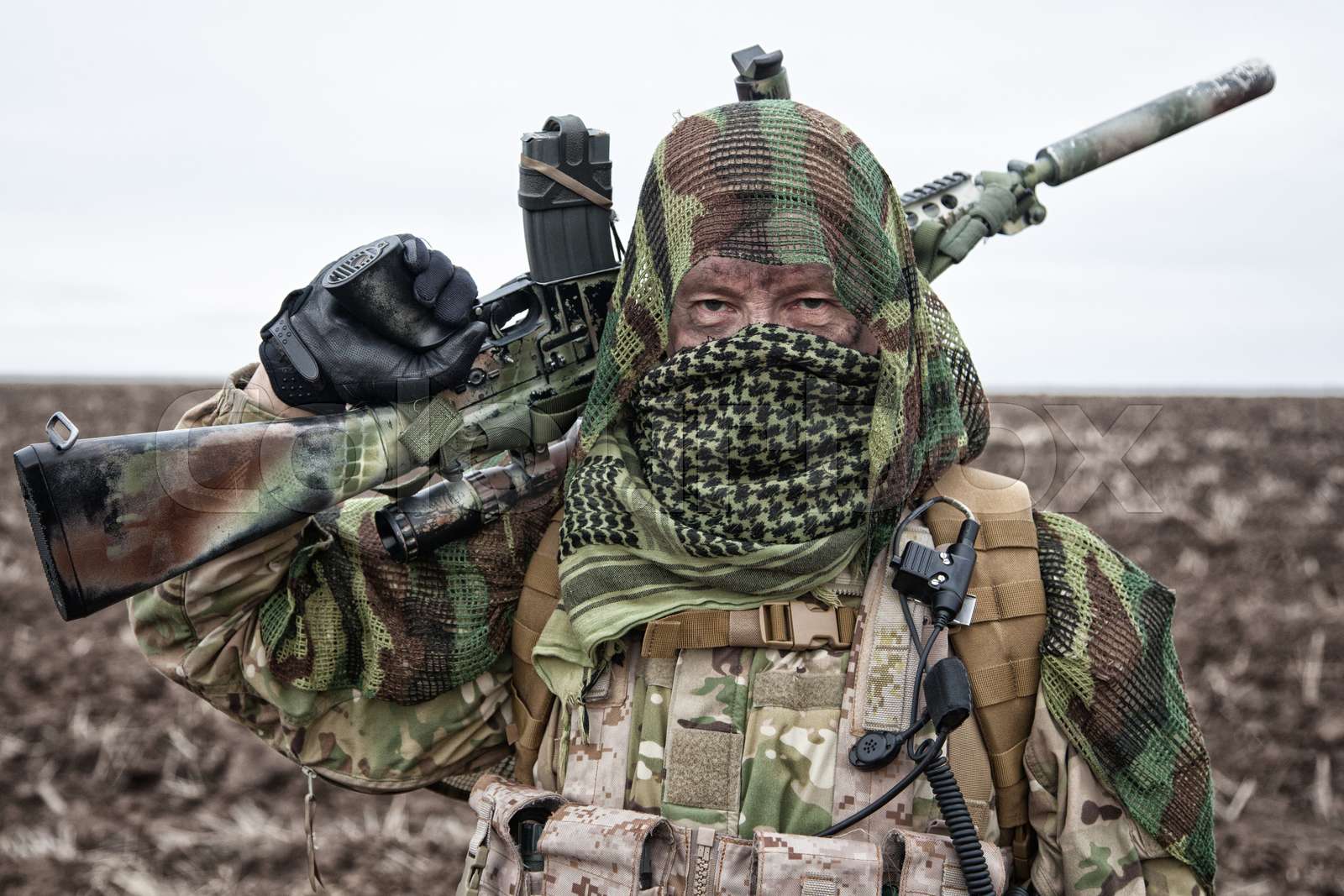 Army sniper standing in field with rifle | Stock image | Colourbox