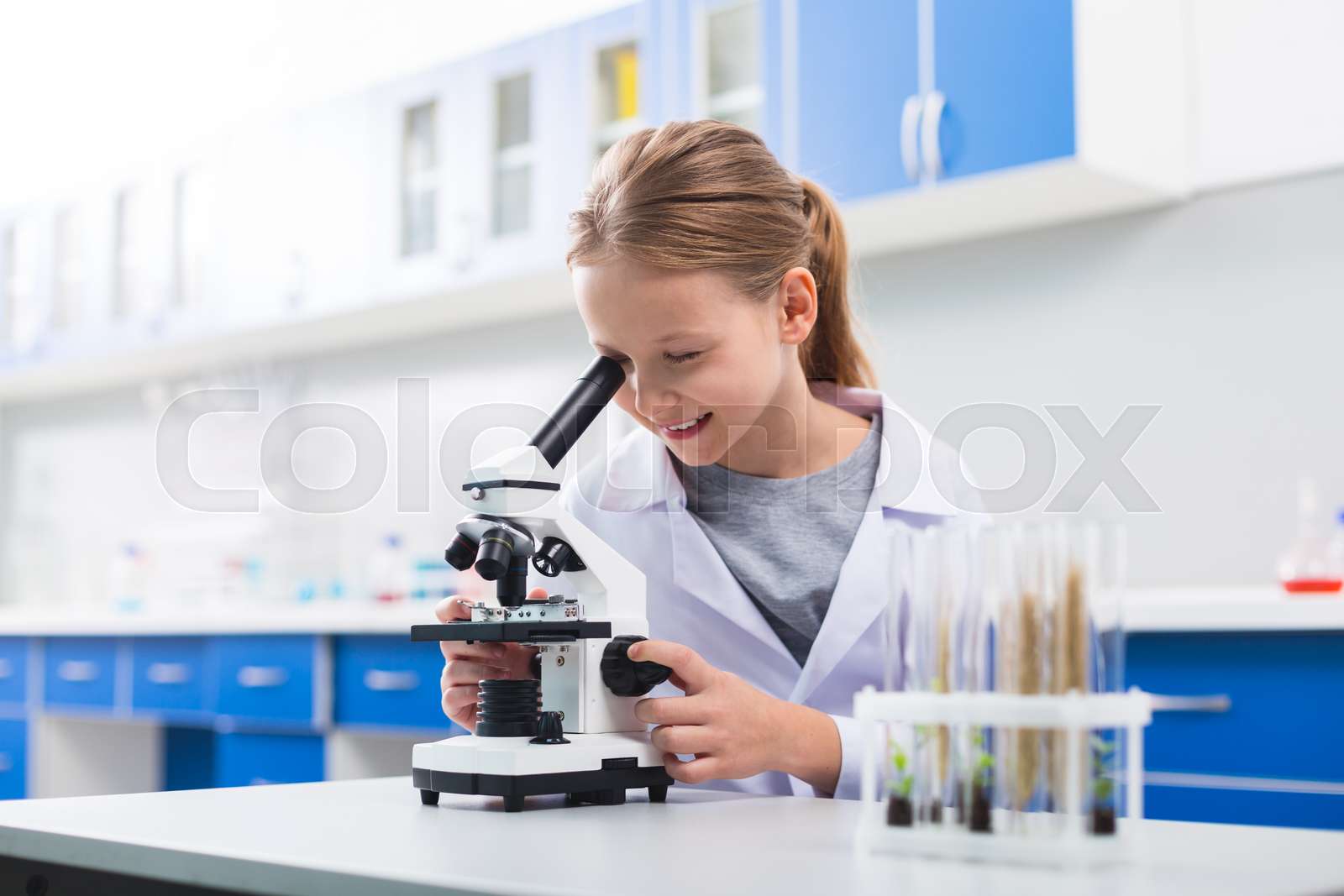 Pretty cute girl looking through microscope | Stock image | Colourbox