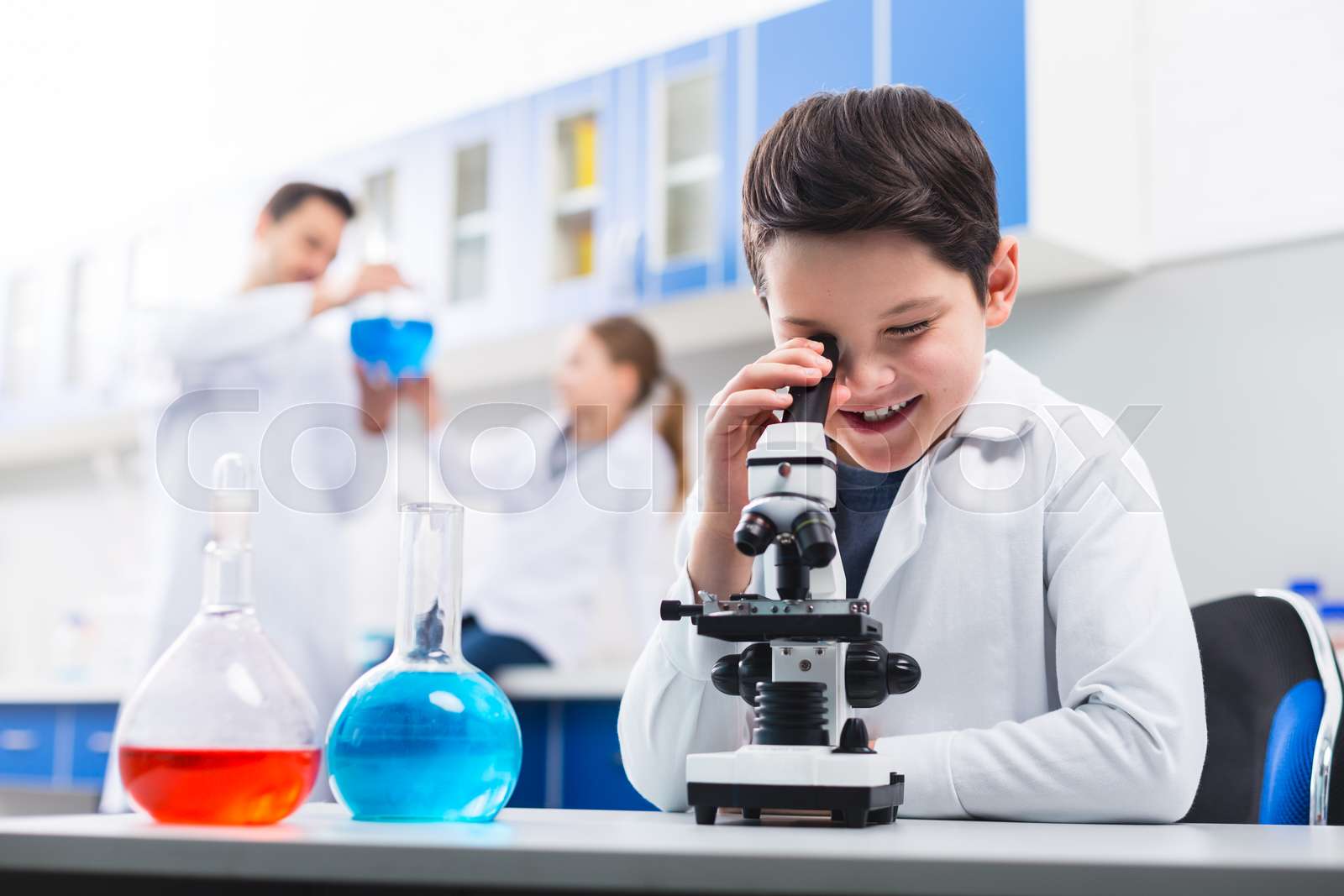 Joyful jolly boy looking through microscope | Stock image | Colourbox