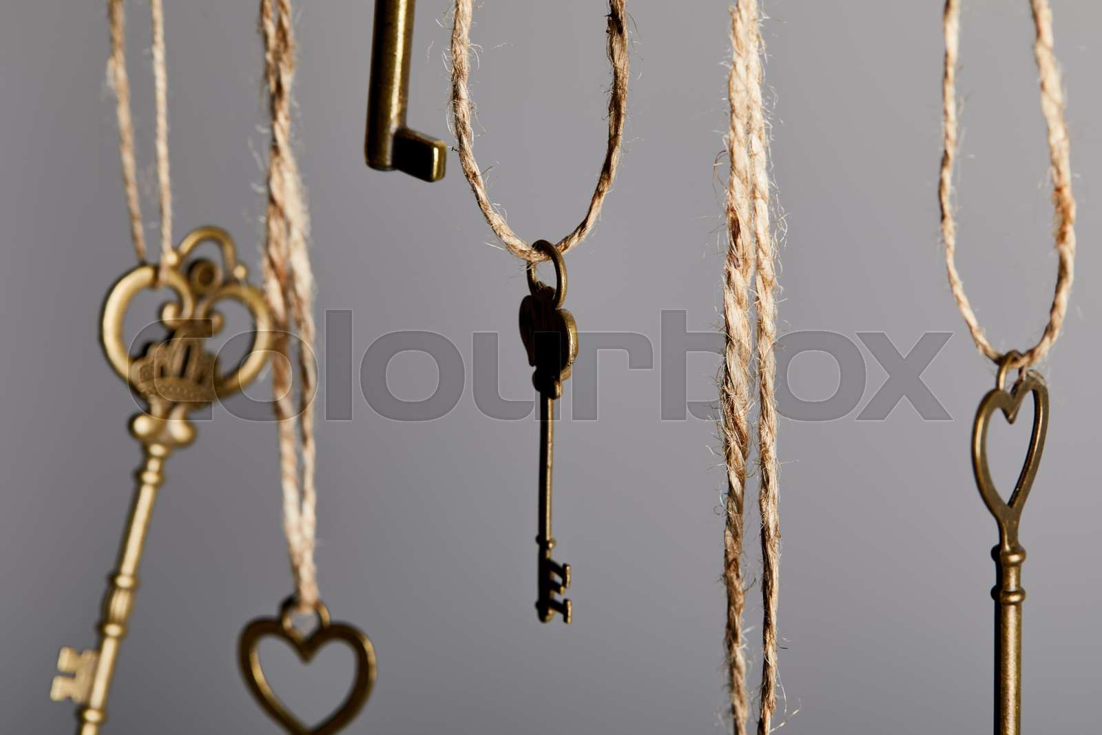 close up view of vintage keys hanging on ropes isolated on grey | Stock ...