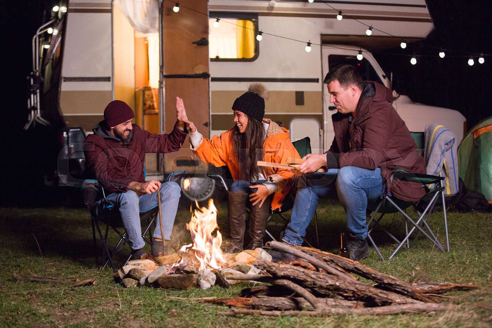 Group of close friends around camp fire laughing | Stock image | Colourbox