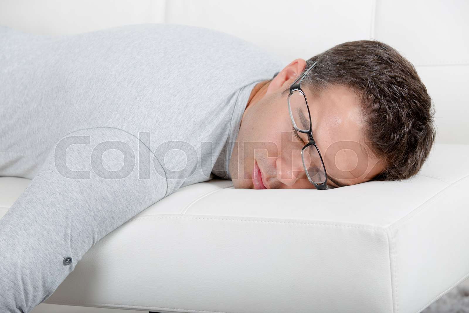 Man snoozing on the sofa | Stock image | Colourbox