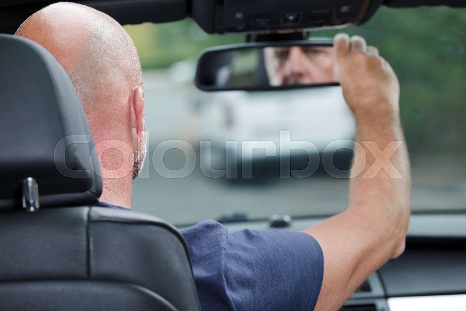 man fixing the rear mirror of the car | Stock image | Colourbox