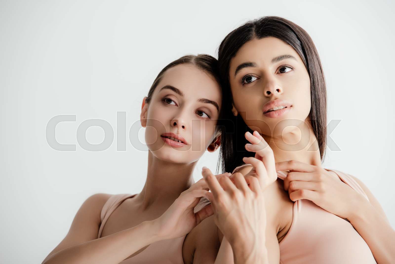young multicultural girls in beige outfit tenderly touching each other isolated on white | Stock ...