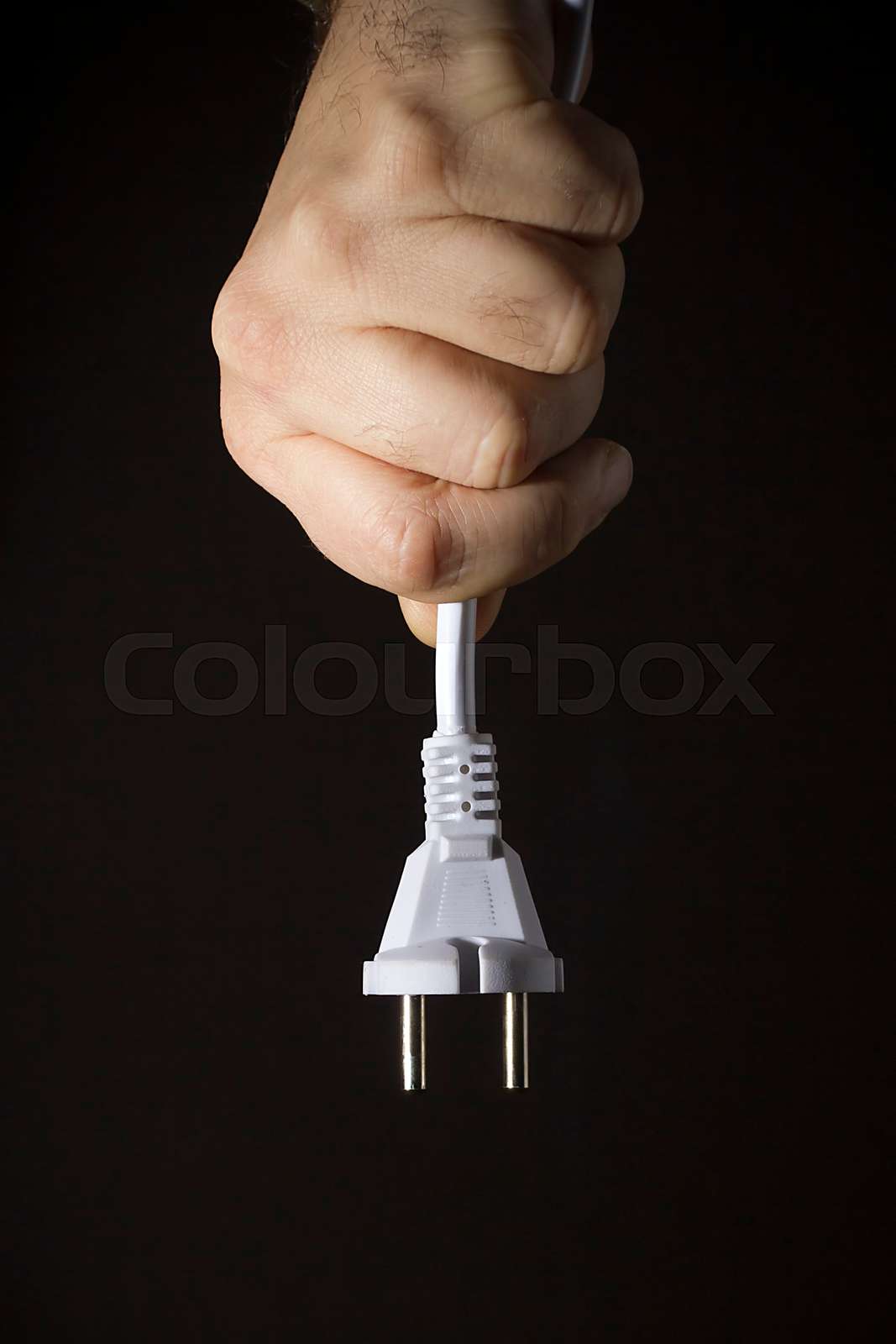Hand with cord and plug | Stock image | Colourbox