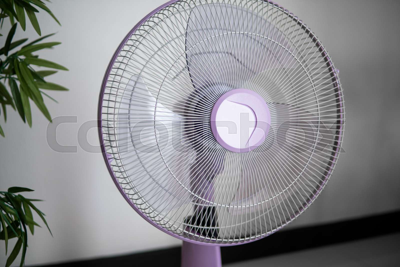 Modern violet electric fan in a living room saving peoples from hot ...