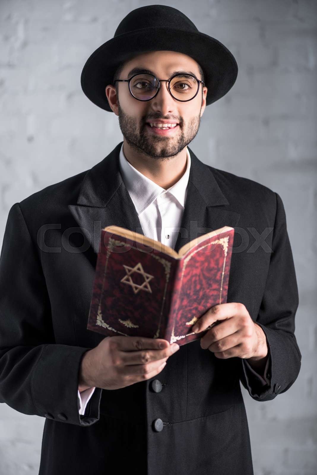 handsome and smiling jewish man in glasses holding tanakh | Stock image ...