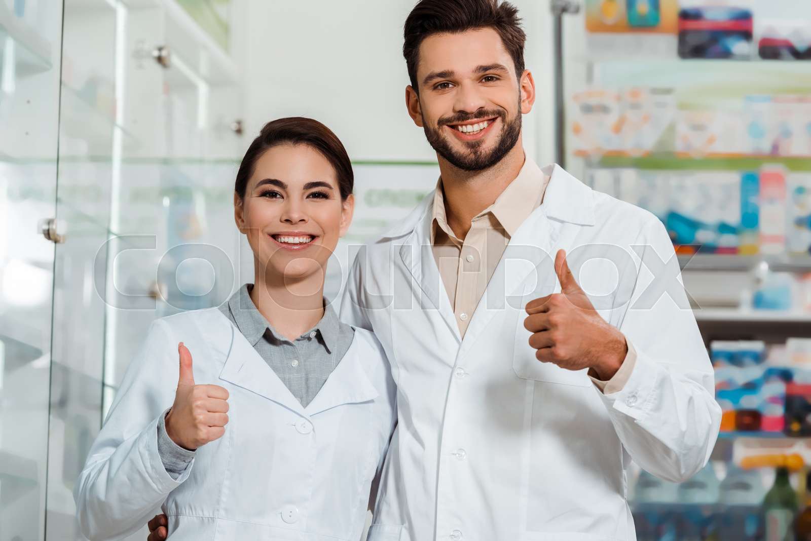 Pharmacists smiling at camera and showing thumbs up in pharmacy | Stock ...
