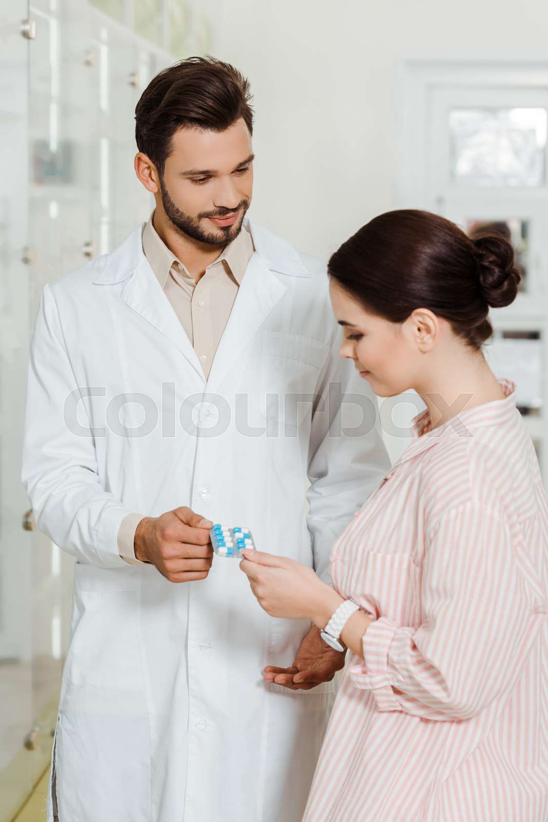 Handsome druggist giving pills to customer in drugstore | Stock image ...