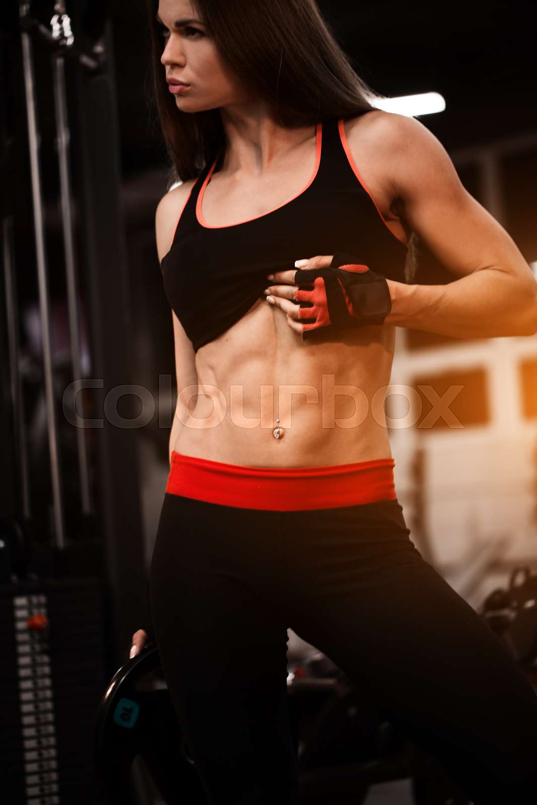 Sporty girl in gym doing exercises and show abs | Stock image | Colourbox