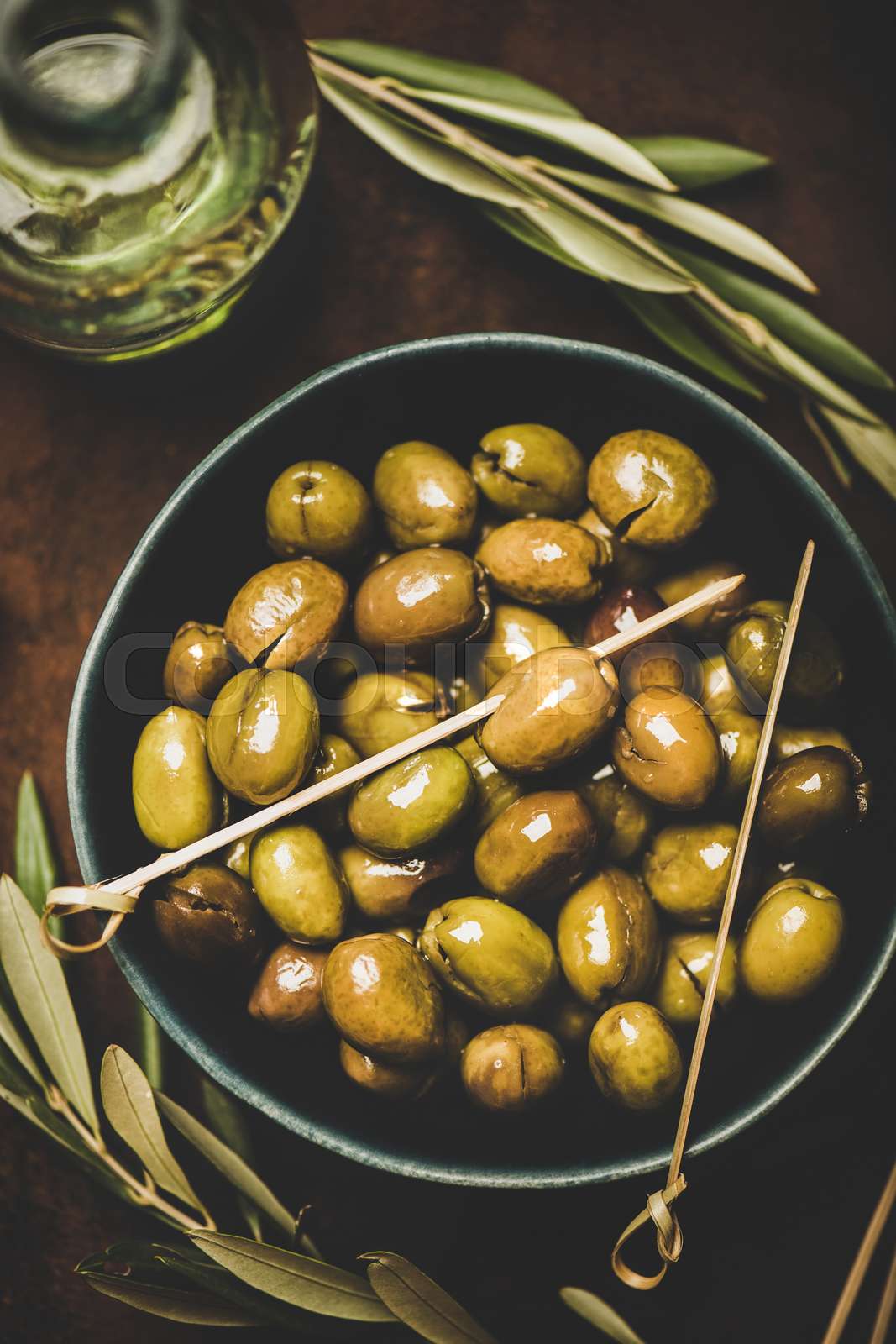 Flat-lay of fresh harvested pickled green Mediterranean olives in bowl ...