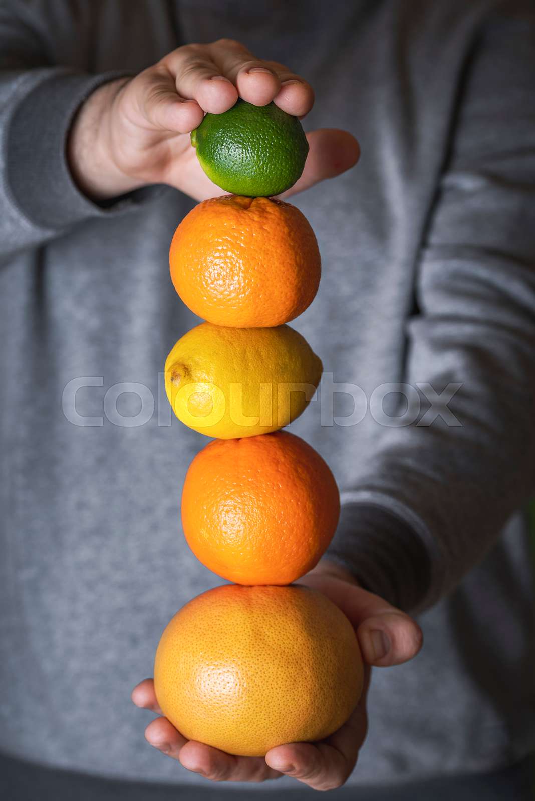 Citrus fruits stack hold in hand. Juicy summer fruits column | Stock ...