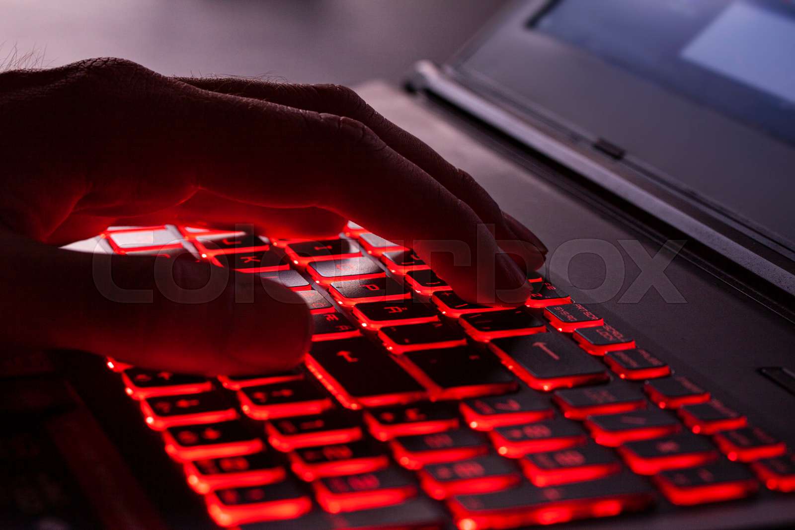 Close up of fingers typing on glowing red backlight keys on a computer keyboard. | Stock image ...