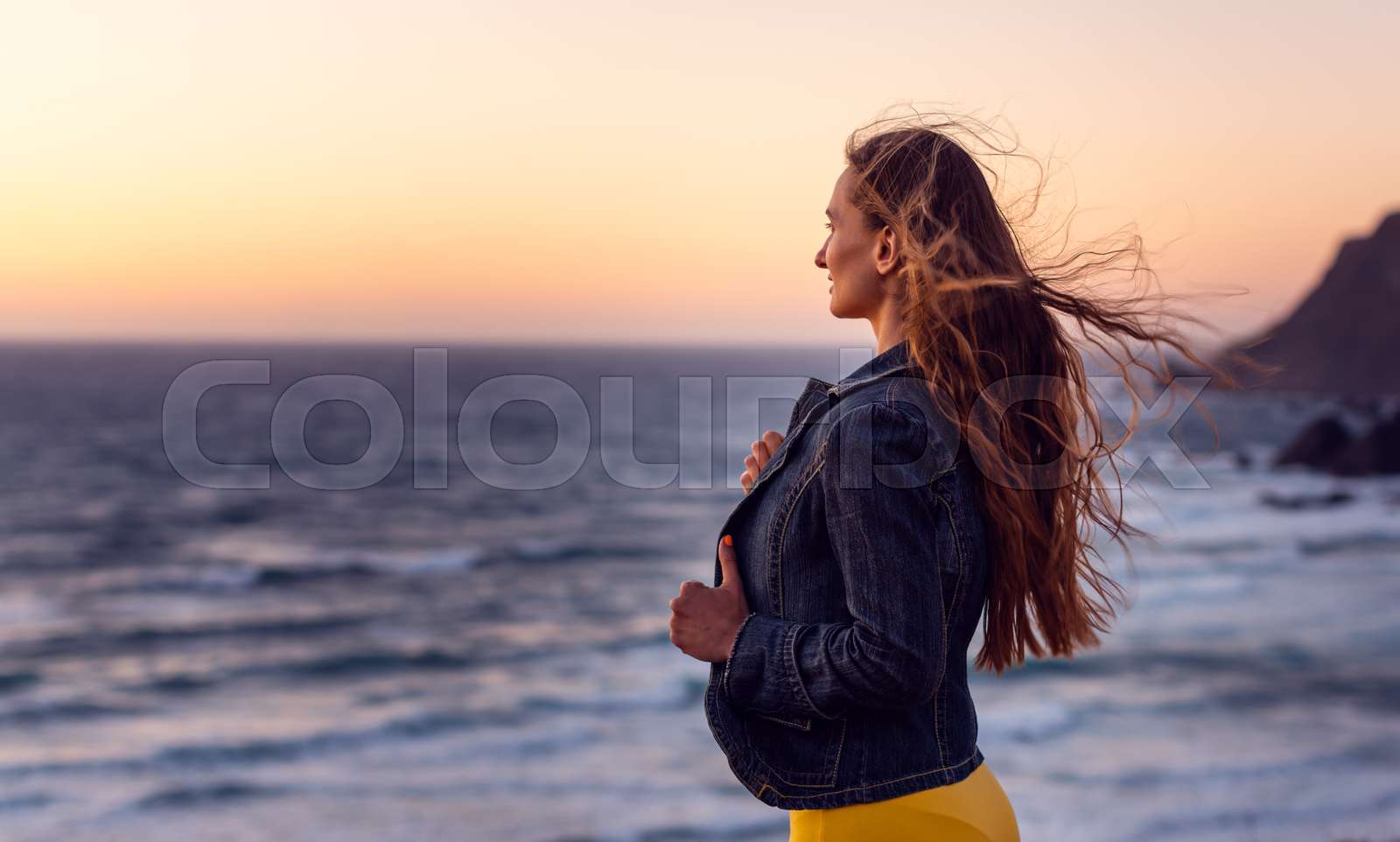 Woman on a sunset beach with the wind in her hair | Stock image | Colourbox