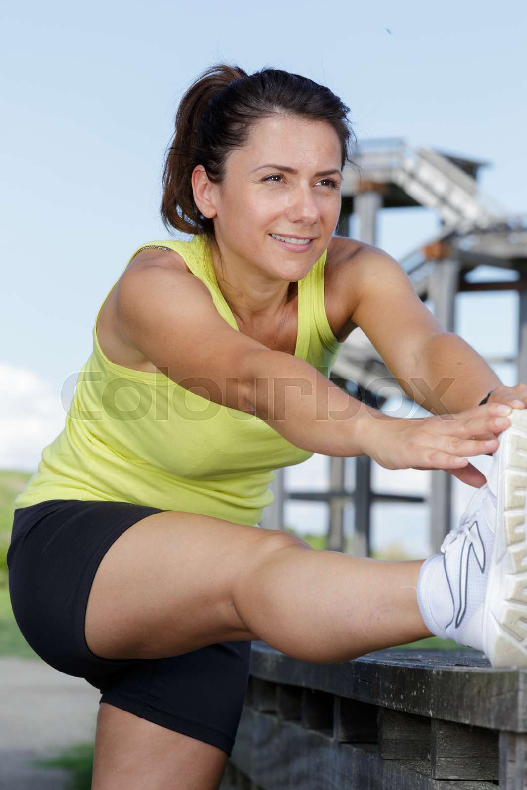 woman stretching her leg while exercising outdoors | Stock image ...