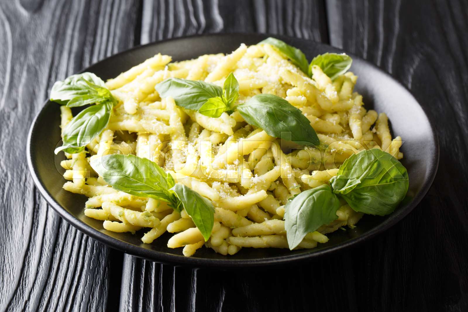 Ligurian trofie pasta cooked with basil pesto and parmesan cheese close ...