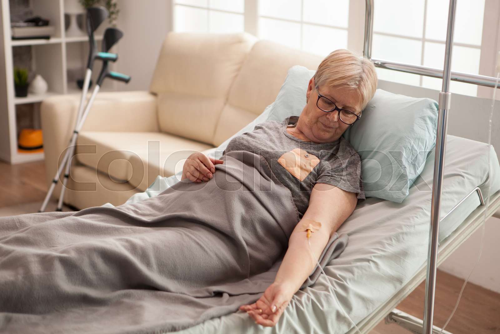 Retired old woman resting in bed in a nursing home | Stock image ...