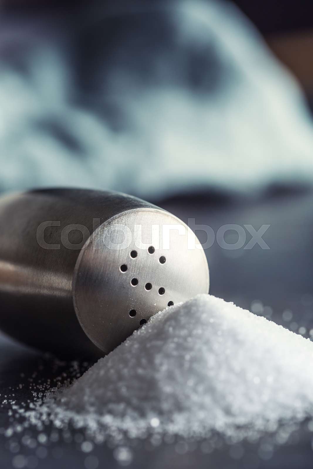 Spilled salt with staniless salt shaker - Closeup | Stock image | Colourbox