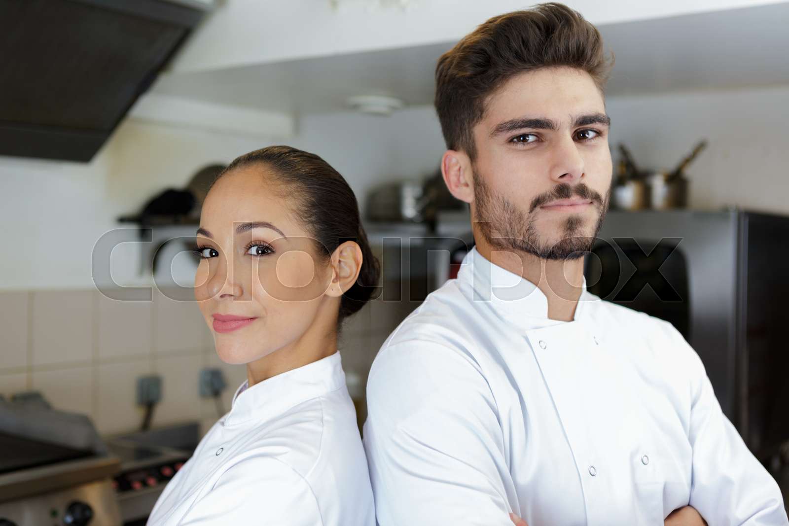 portrait of male and female chefs back to back | Stock image | Colourbox