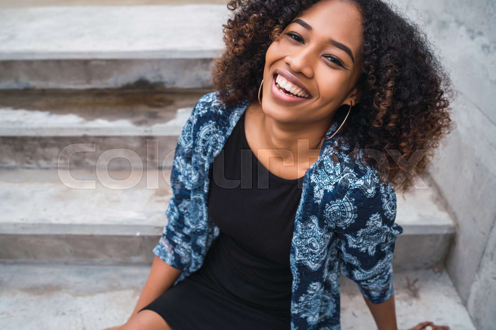Afro-american woman sitting on steps. | Stock image | Colourbox