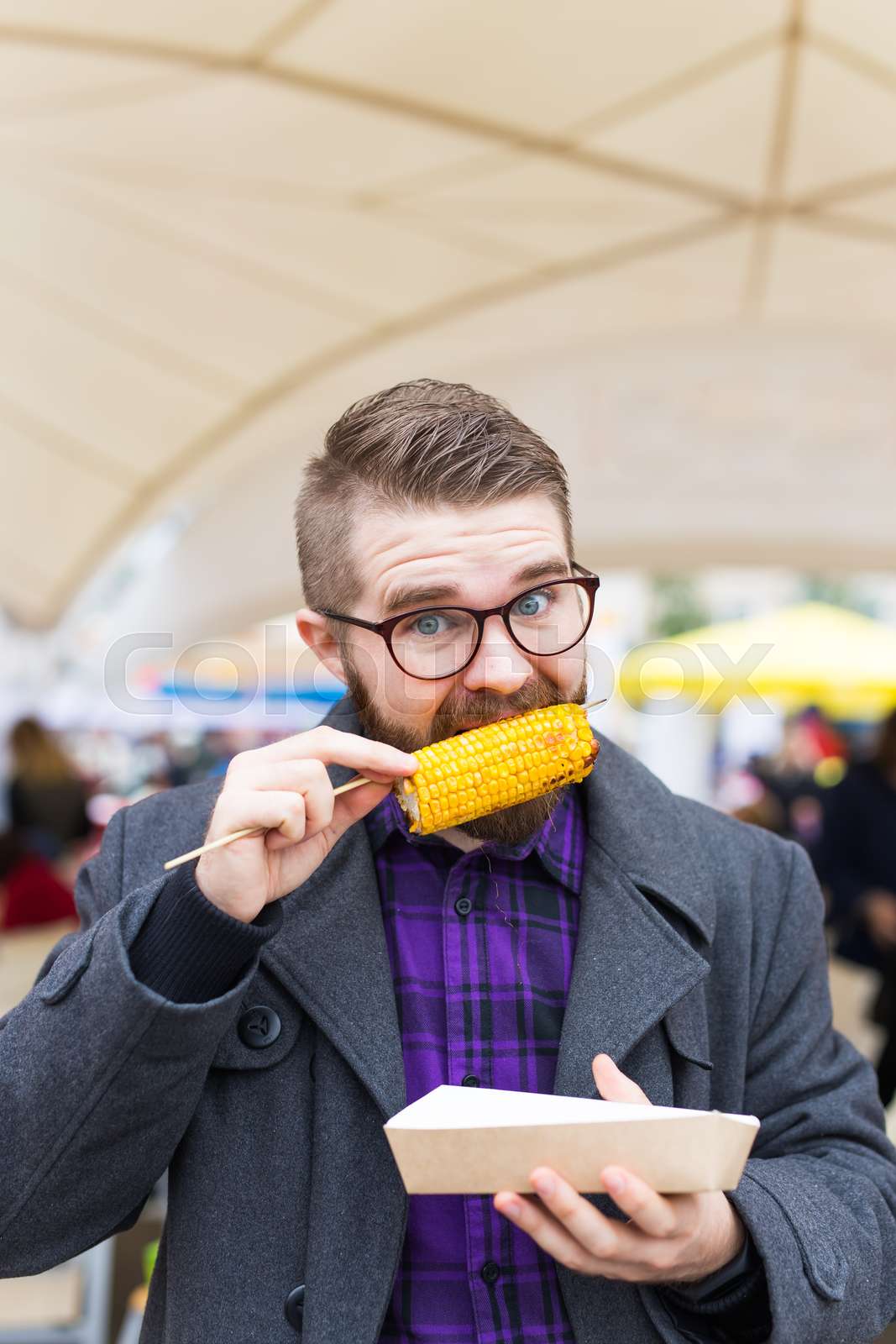 Vegetarian and meal concept - Handsome man eating street food corn at ...