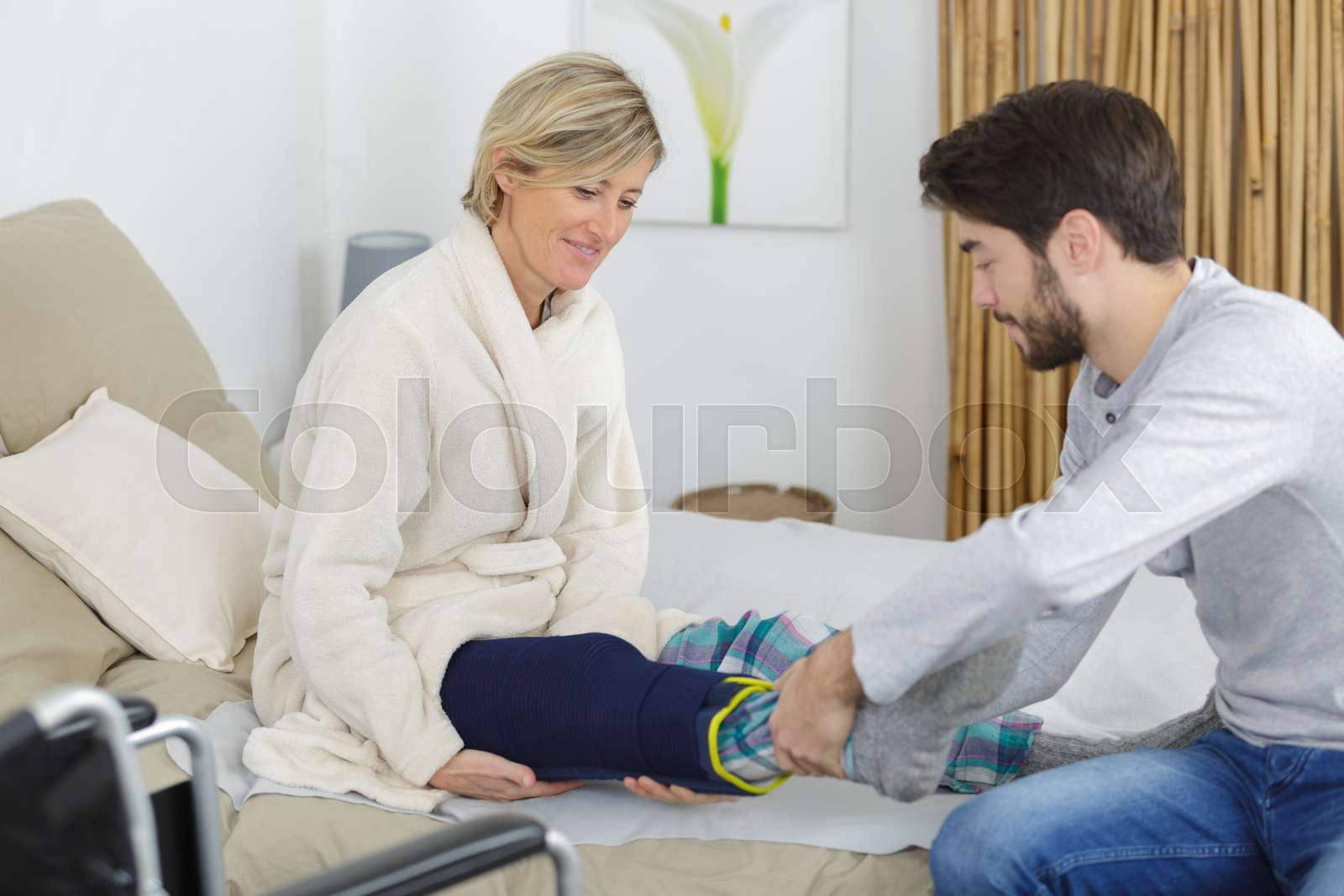 patient with broken leg in bed with assistance | Stock image | Colourbox