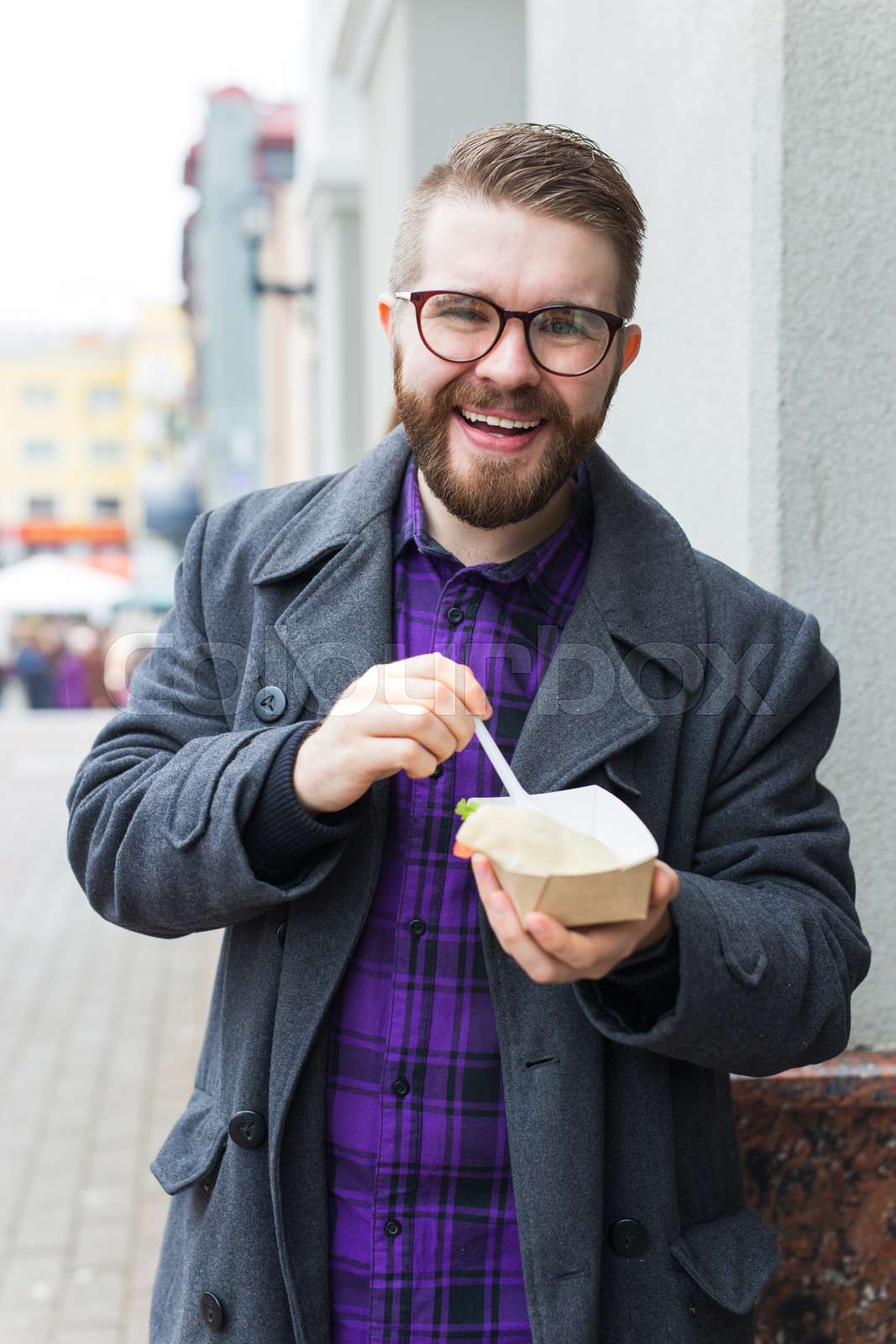 Fast food and meal concept - Young man eating take away food on the ...