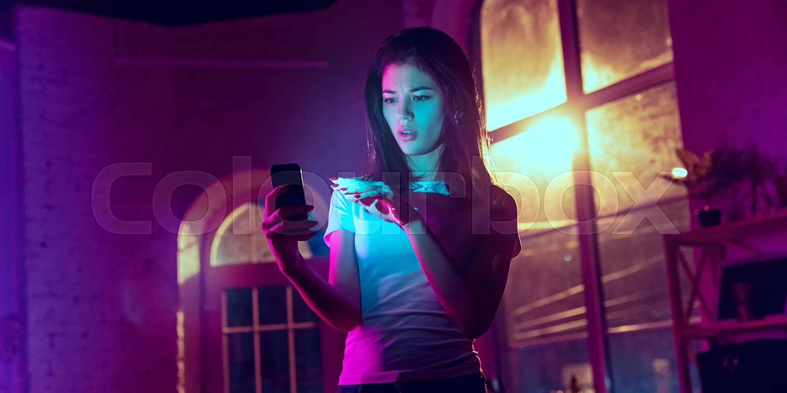Cinematic portrait of handsome young woman in neon lighted interior ...